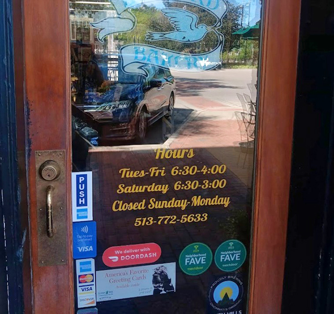Business hours etched on glass&mdash;the fine print of happiness that smart visitors photograph immediately to avoid disappointment later.
