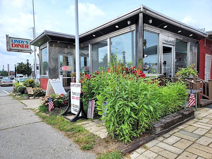 Flowers frame Lindy's glass exterior like nature's own Instagram filter, softening the diner's utilitarian edges with unexpected beauty.