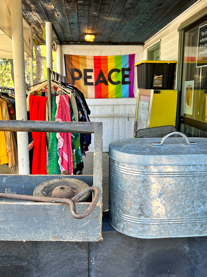 The porch display announces the store's peaceful philosophy with a rainbow flag, while vintage clothing waits patiently for new adventures.