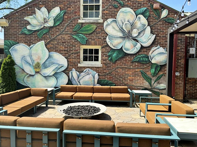 The outdoor lounge area, complete with magnolia mural, proves that Southern charm extends beyond the dining room at Mere Bulles.