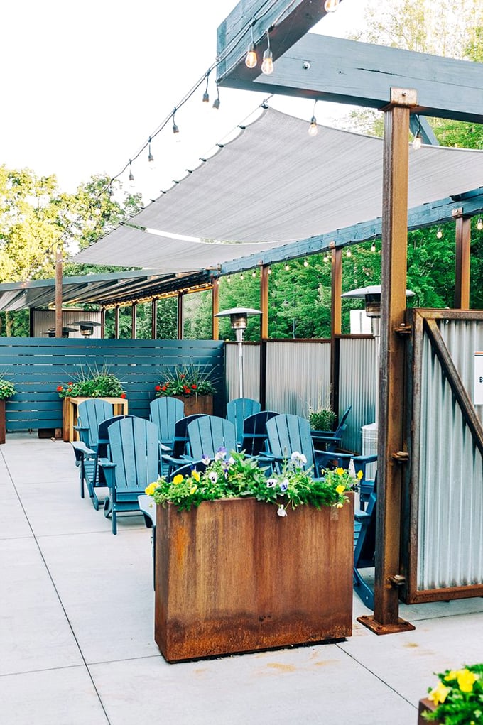 The outdoor patio offers a serene retreat with Adirondack chairs and string lights. Vermont's natural beauty provides the perfect backdrop for barbecue bliss.