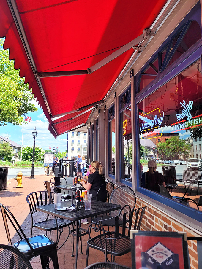 The outdoor seating area offers front-row tickets to Gettysburg's charm, where red awnings provide shade for both your burger and your sunburned shoulders.