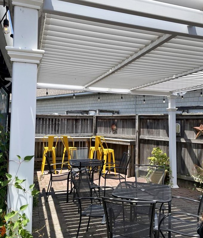 Outdoor seating that captures the essence of casual coastal dining. Those yellow barstools are practically begging for sunset cocktails.