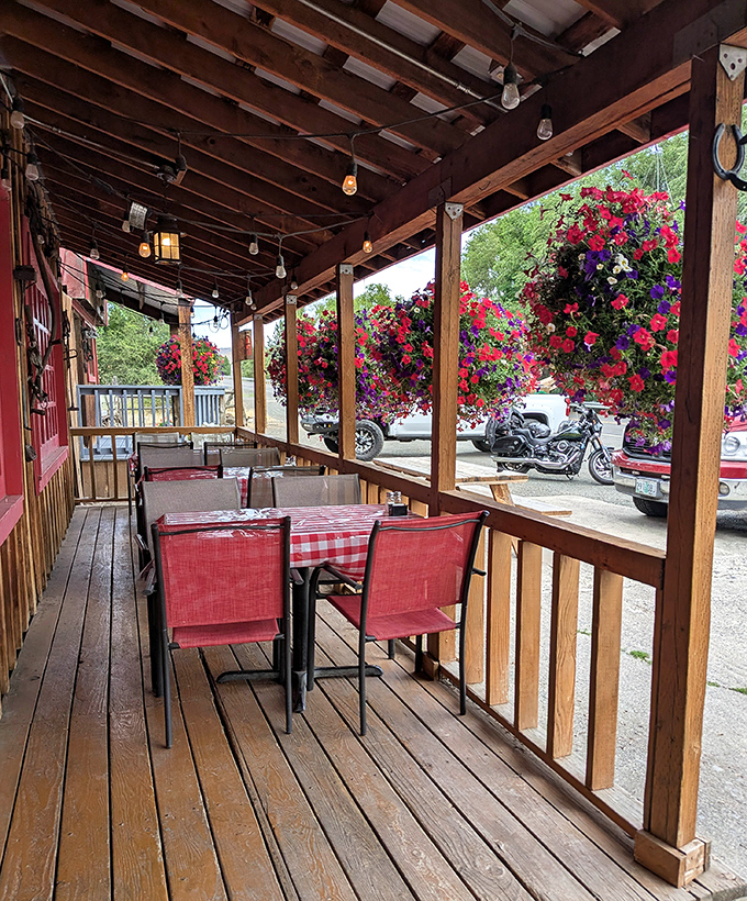 The covered porch with red-checkered tablecloths offers front-row seats to small-town life—dinner and a show, Dayville-style.