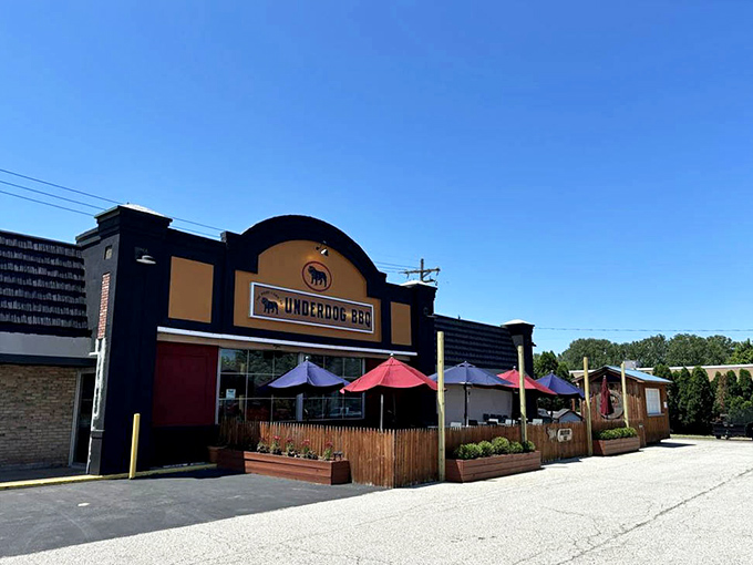 The distinctive arched facade of Underdog BBQ stands proud against the blue sky, a temple to smoke, sauce, and satisfaction in Erie.