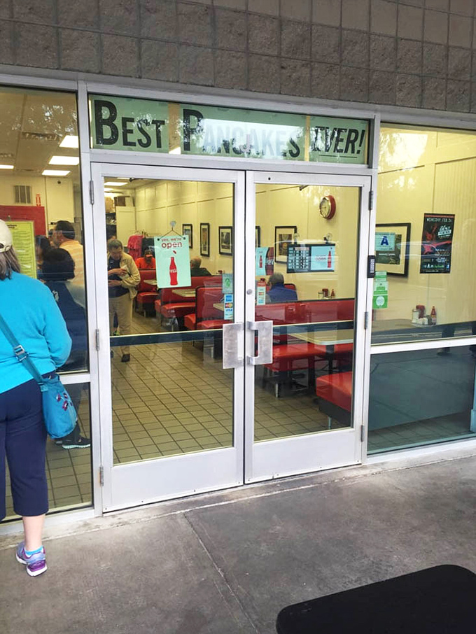 The glass doors reveal the promised land of breakfast delights, where red booths await to cradle you through your pancake-induced euphoria.