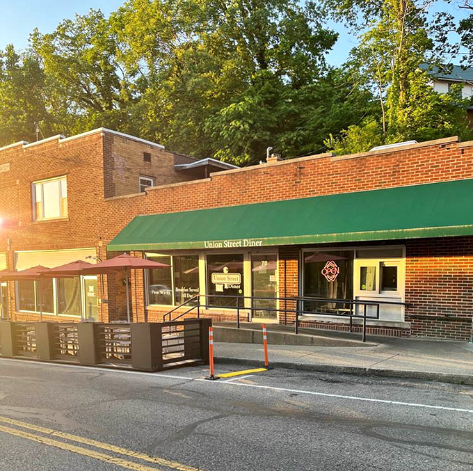 Golden hour sunlight bathes the exterior while that green awning promises comfort food waiting just inside those doors.