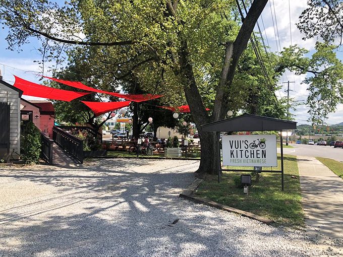 Red sun shades flutter like welcome flags above the outdoor dining area, inviting passersby to pause for a Vietnamese adventure.