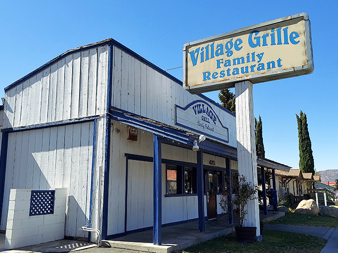Against the backdrop of mountain air and blue skies, the Village Grille's weathered sign promises exactly what you'll find inside: honest food served with care.