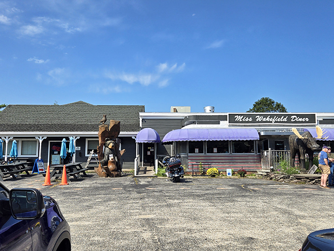 Even the wooden bear statue outside seems to be saying, "You've found the right place." The purple awnings and picnic tables promise a genuine New Hampshire experience.