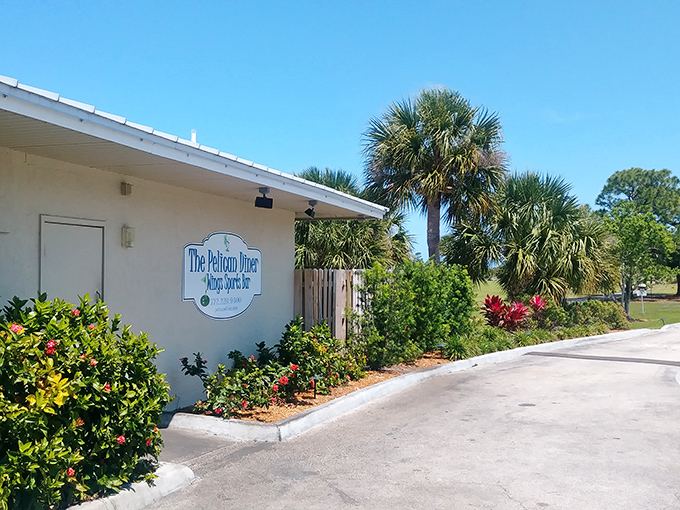 Palm trees stand tall beside the Pelican Diner sign – a tropical welcome committee for hungry travelers seeking authentic Florida flavors.