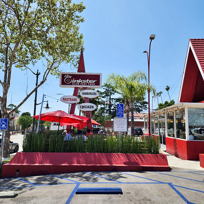 The outdoor patio, where California sunshine meets California cuisine, and red umbrellas provide shade for serious burger contemplation.