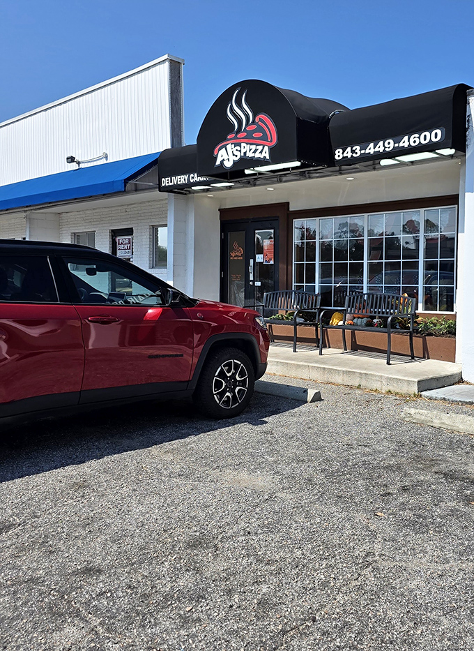 The parking lot view that locals know by heart &ndash; where your car waits patiently while you indulge in what might be the best pizza decision of your vacation.