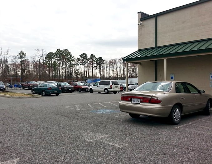 The parking lot&mdash;final resting place for cars whose owners entered for "just a quick look" three hours ago. They're still inside, elbow-deep in potential.