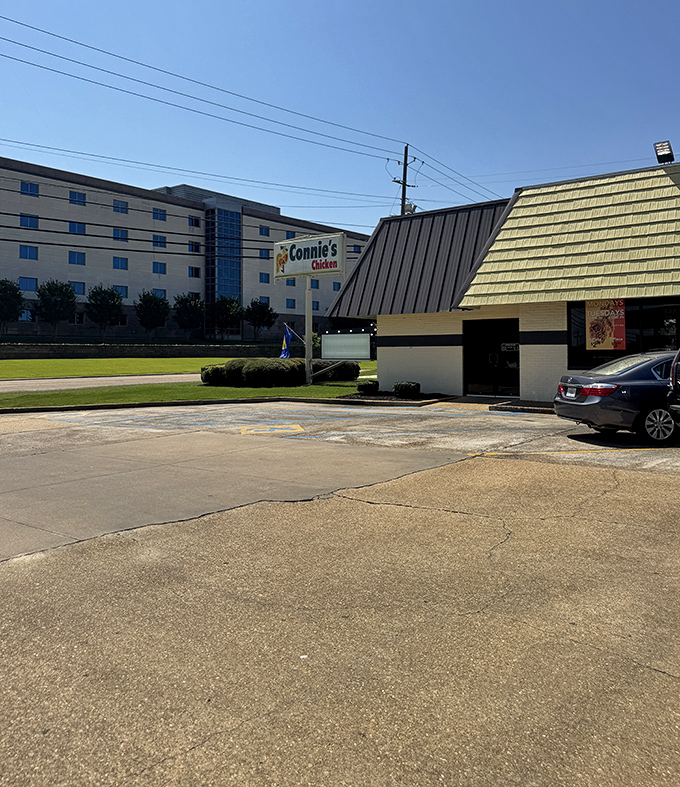 The exterior view shows Connie's Chicken standing proudly against the backdrop of modern development, a testament to timeless quality over passing trends.