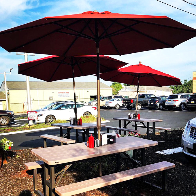 Red umbrellas standing guard over outdoor tables&mdash;because sometimes pancakes taste even better with a side of fresh air.