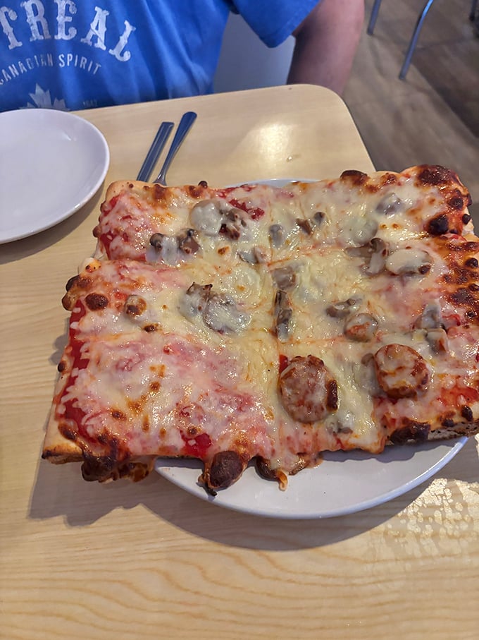 That rectangular slice loaded with sausage and mushrooms is Old Forge-style pizza in all its glory.