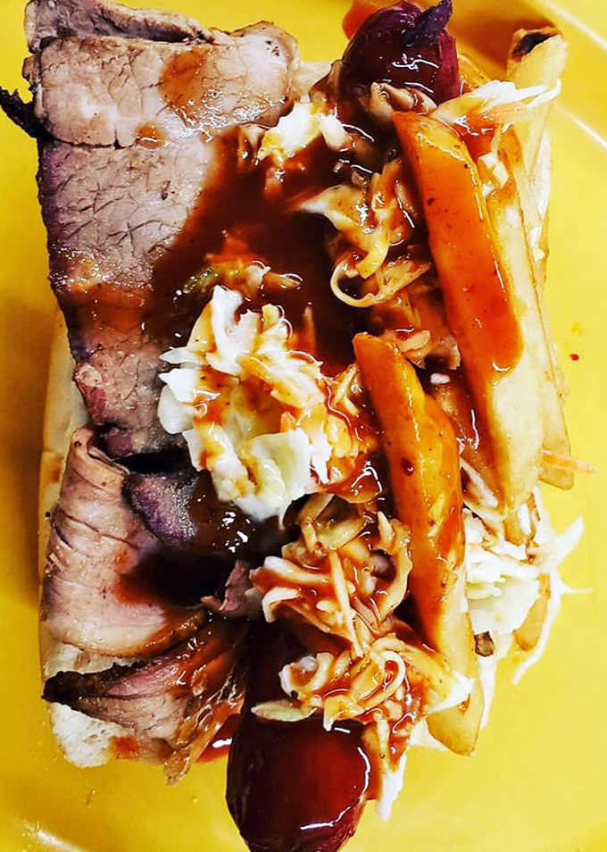 A Polish sandwich adorned with slaw and sauce on a bright yellow plate. Like a barbecue rainbow with a pot of deliciousness at the end.