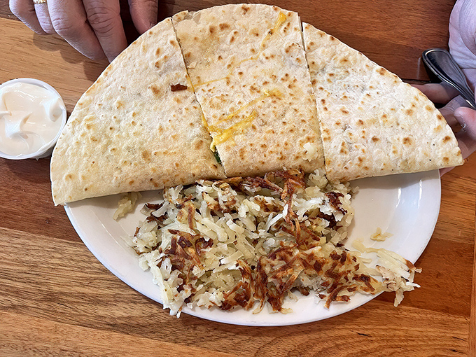 Quesadilla perfection: golden-brown tortilla quartered to reveal melty goodness inside, with crispy hashbrowns standing by for the assist.