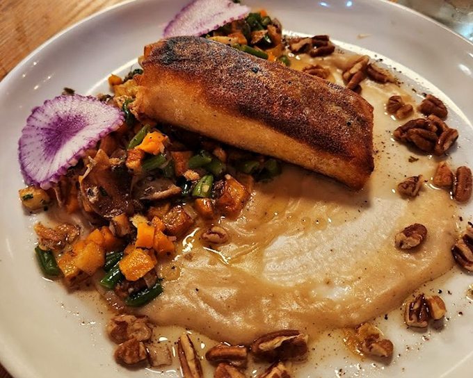 Salmon Wellington&mdash;where fish meets puff pastry in a marriage blessed by the culinary gods, surrounded by seasonal vegetables and pecan confetti.