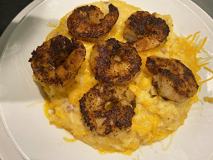 Blackened shrimp crown a bed of creamy grits like jewels on velvet. Southern comfort meets Maryland seafood in a dish that demands to be savored.
