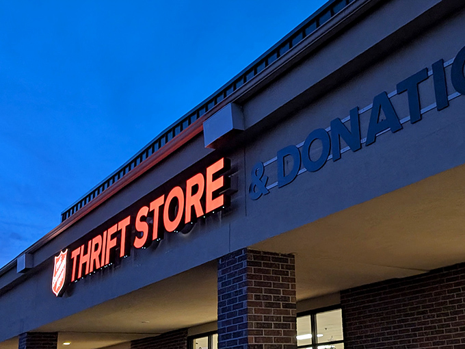 As evening falls, the illuminated sign beckons like a lighthouse for bargain seekers. Tomorrow brings new donations and new possibilities.