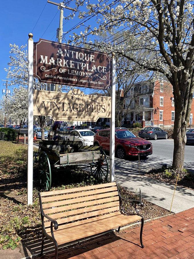 Spring blossoms frame the marketplace sign like nature's endorsement. That bench invites you to rest before or after your antiquing adventure.