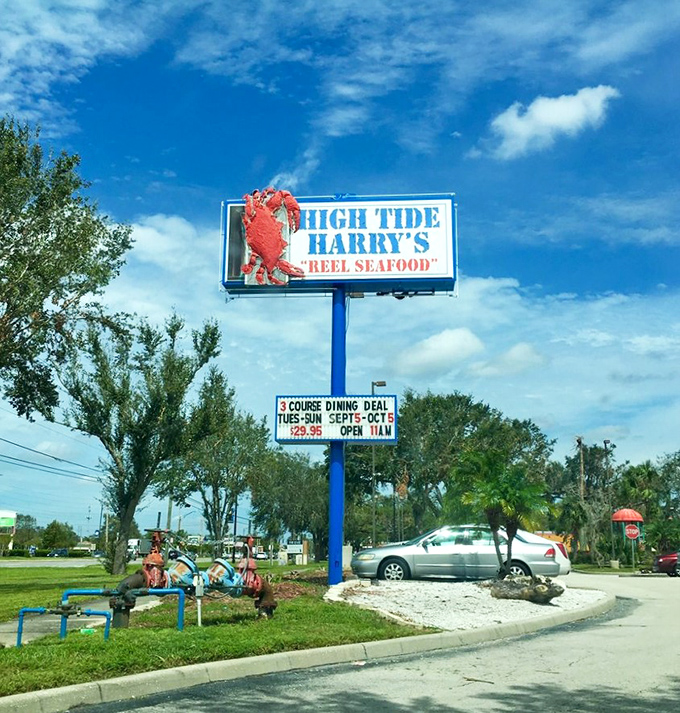 The roadside sign featuring a giant red crab serves as a beacon for seafood lovers, promising "REEL SEAFOOD" without a hint of irony.