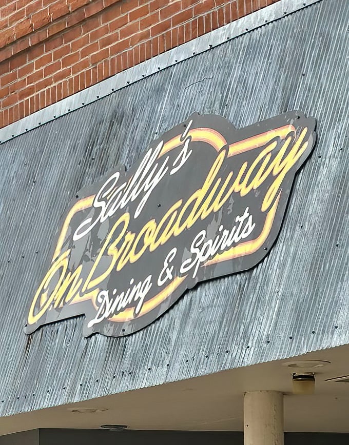 The illuminated Sally's sign glows like a beacon in the night, guiding hungry travelers to tenderloin paradise since long before GPS existed.