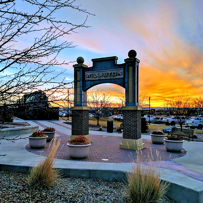 Williston's entrance arch captures a perfect sunset, framing the sky's dramatic colors like nature's own welcome sign to this charming prairie town.
