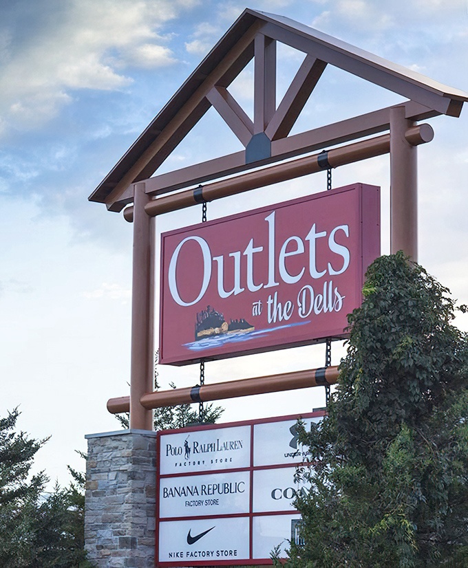 The iconic Outlets at the Dells sign stands like a retail lighthouse, guiding bargain hunters safely to shore. Polo Ralph Lauren, Banana Republic, and Nike await below.