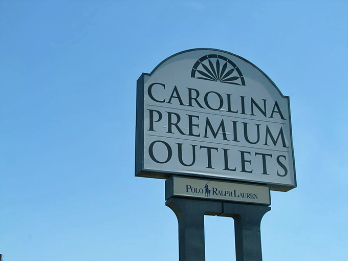 The iconic Carolina Premium Outlets sign stands tall against the blue sky, a retail lighthouse guiding bargain hunters safely to shore.