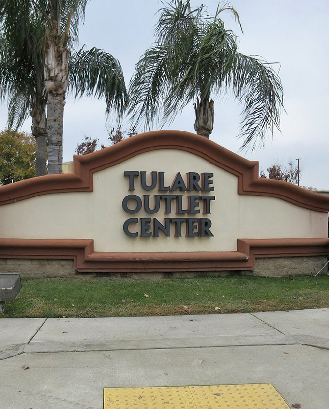 Palm trees frame the Tulare Outlet Center sign like exclamation points. Nature's way of saying "Major deals ahead!"