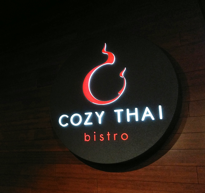The illuminated sign glows like a beacon in the night, guiding flavor-seekers to their Thai food destiny. Follow the red flame!