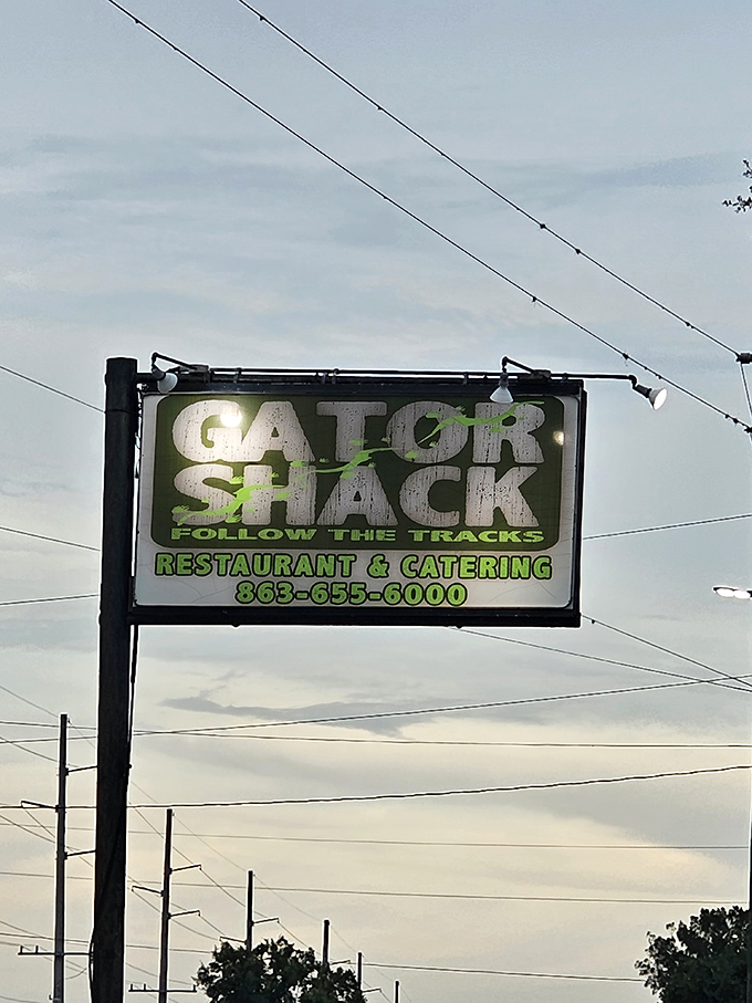 The Gator Shack sign glows against the twilight sky, beckoning hungry travelers to "Follow The Tracks" to authentic Florida flavor.