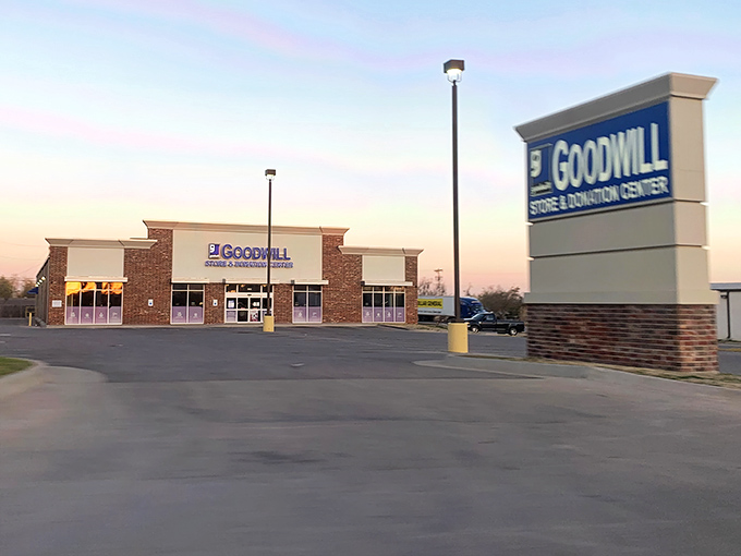 As dusk settles, the Goodwill sign glows like a lighthouse for bargain hunters. Tomorrow's treasures are already being sorted inside, ready for another day of discovery.