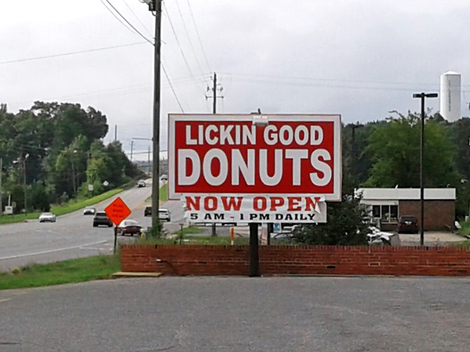 The roadside sign announces operating hours of 5 AM to 1 PM daily&mdash;a gentle reminder that the early bird gets the still-warm donut.