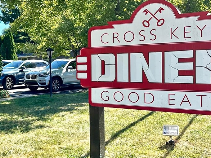 The Cross Keys Diner sign stands proud against Pennsylvania greenery, like a lighthouse guiding hungry travelers to the shores of good eating.