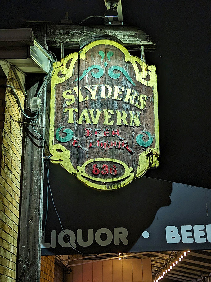 At night, the vintage sign transforms into a neon beacon, guiding hungry pilgrims to burger paradise since 1948.