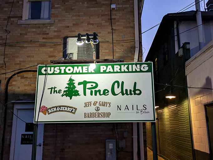 The parking sign glows like a beacon in the night, guiding hungry pilgrims to the promised land of perfect ribeyes.