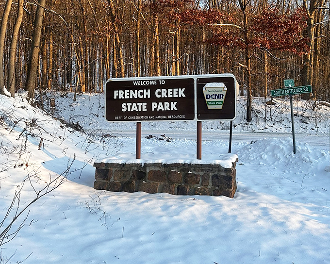 Welcome sign dusted with snow&mdash;nature's way of saying "closed for redecorating." Winter's transformation is worth the cold fingers.
