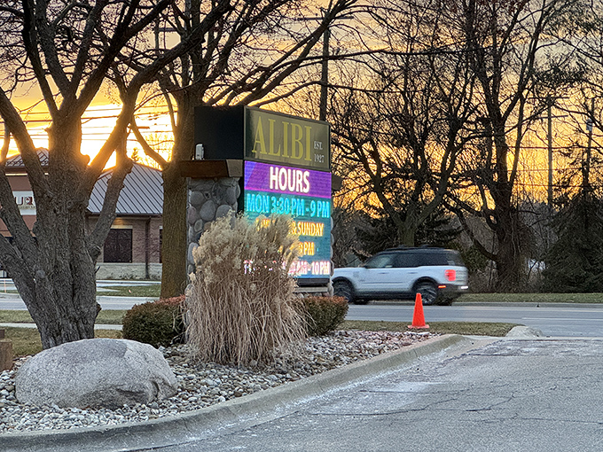 As dusk settles over Troy, the Alibi sign glows like a beacon, guiding hungry travelers to a Michigan dining institution.