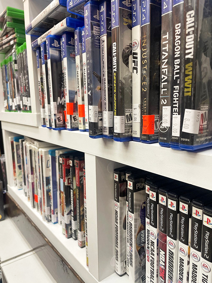 Video game history lines these shelves, each plastic case a portal to countless hours of digital adventures from generations past.
