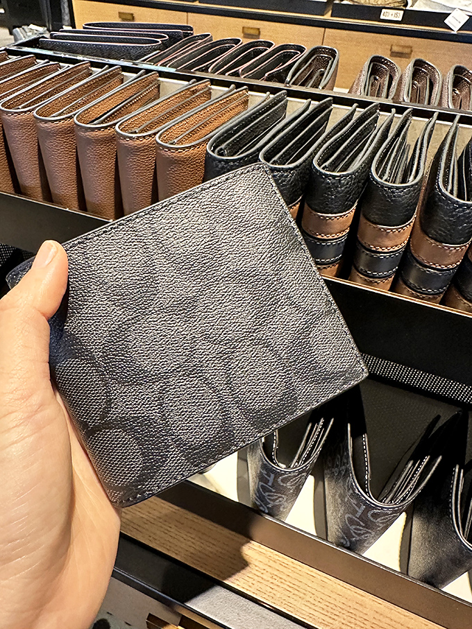 A Coach wallet in its natural habitat, surrounded by its leather-bound brethren. At outlet prices, it's practically begging to hold your credit cards.