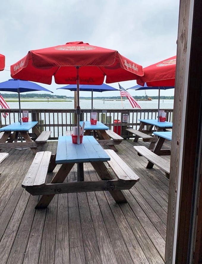 The waterfront deck at Chick's&mdash;where picnic tables under red umbrellas offer front-row seats to nature's best dinner theater: the Lynnhaven Inlet.