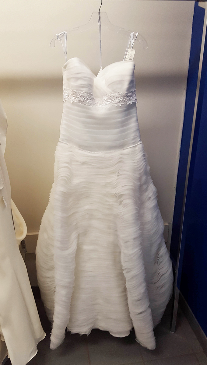 Wedding dresses get their second chance at romance, this pristine gown waiting patiently for another walk down the aisle at a fraction of bridal boutique prices.