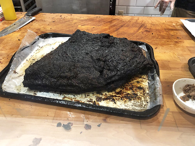 A whole brisket rests like a sleeping giant, ready to feed the masses magnificently.