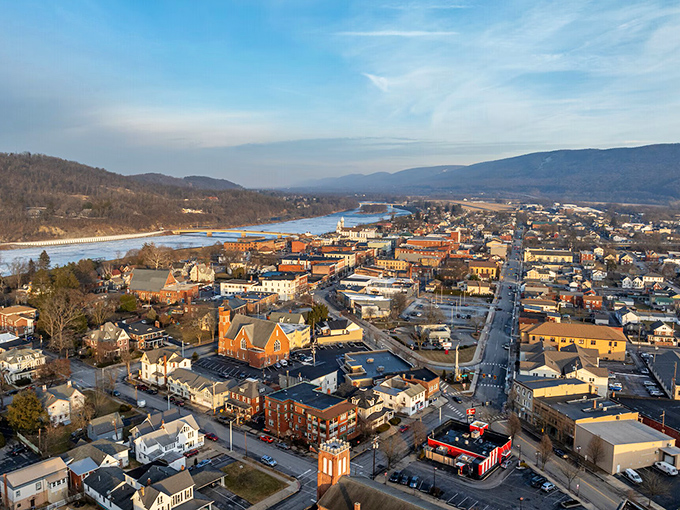 This aerial view reveals Lock Haven's perfect positioning&mdash;nestled between mountains and river, offering natural beauty without the natural disaster of big-city prices.