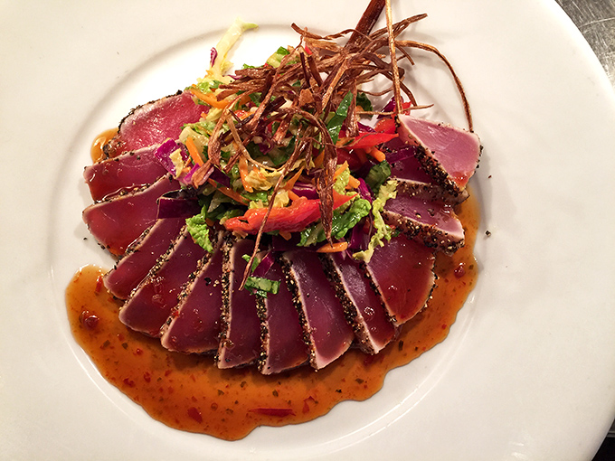 Seared ahi tuna, ruby-red and sesame-crusted, fanned out like a deck of cards dealt by a chef who knows exactly how to play your taste buds.