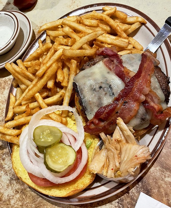 Bacon cheeseburger with fries stacked high, because sometimes dinner needs to look like it means serious business.
